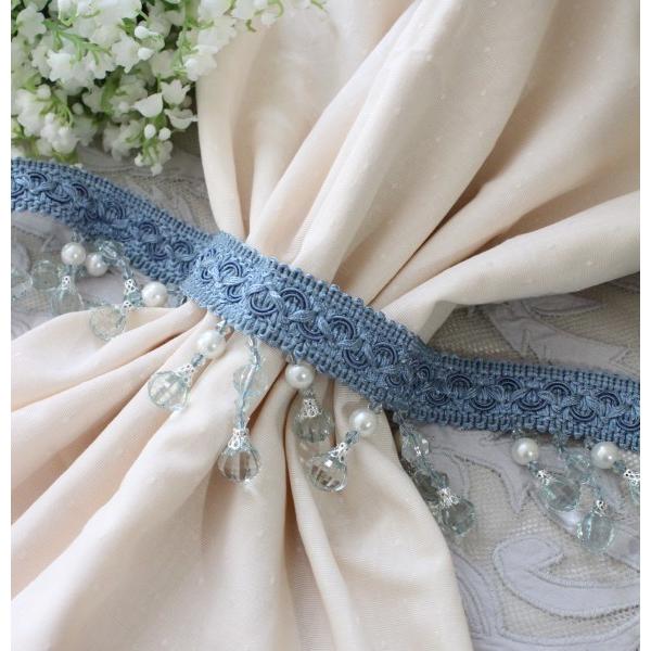 [商品説明]タッセルやビーズがあしらわれた可愛いカーテンタイバックカーテンをお留頂くのにご使用頂くアイテムですフリンジの左右には輪が付いておりますので、そちらにてカーテン留め金具にお掛け下さいませこちらのお色はブルーにドロップ型のビーズ＆パ...