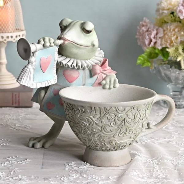 [商品説明]シャビーシックなパステルカラーがおしゃれな印象のカエルのティーカップ付きオブジェハートのトランプ柄の衣装を着てラッパを吹くプリンスのカエルですクラシカルなアラベスク模様のティーカップには造花やグリーンを飾ったり、小物入れとして使...