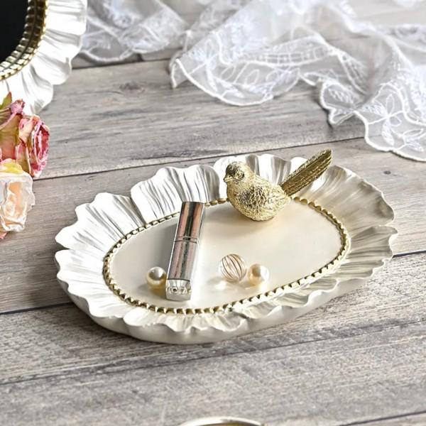 [商品説明]花びらのようなフリルの縁取りがかわいいアクセサリートレー華やかなパールホワイトカラーにゴールドカラーの小鳥を乗せたかわいいデザインで空間を明るくしてくれますアクセサリーや時計、スマホやステーショナリーなどを置くのに活躍するデザイ...