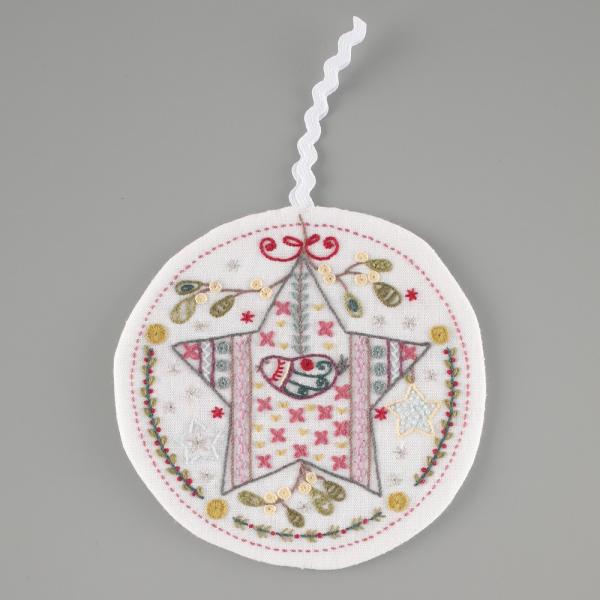 クリスマスオーナメントにぴったりのキットが登場です。星の中に小鳥がデザインされています。紐もついていますので、ドアや窓辺に飾って楽しめます。【内容物】　日本語訳解説書、フランス語解説書、使用糸カラーチャート、下絵印刷済み布（白）、刺しゅう糸...