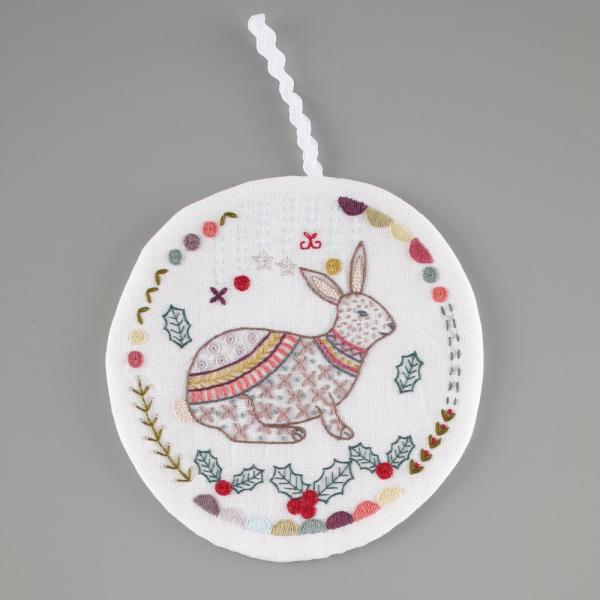 クリスマスオーナメントにぴったりのキットが登場です。うさぎがモチーフになっています。紐もついていますので、ドアや窓辺に飾って楽しめます。【内容物】　日本語訳解説書、フランス語解説書、使用糸カラーチャート、下絵印刷済み布（白）、刺しゅう糸、刺...