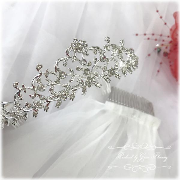 花嫁様を引き立てるシンプルデザインのティアラです両端にコームがついていますので 動いても 感動的なベールアップもズレることなく安心です結婚式や二次会など花嫁様にお勧めのウエディングティアラ。ラインストーンが上品に輝き、お花モチーフが可愛いテ...