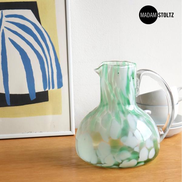 透明・グリーン・ホワイトがやわらかく溶け合う、表情豊かなガラスジャグ。ガラスの中に浮かぶような斑点模様が光を受けて美しく映え、食卓や棚の上にさりげない彩りを添えてくれます。水差しとしてはもちろん、フラワーベースのように飾っても絵になる佇まい...