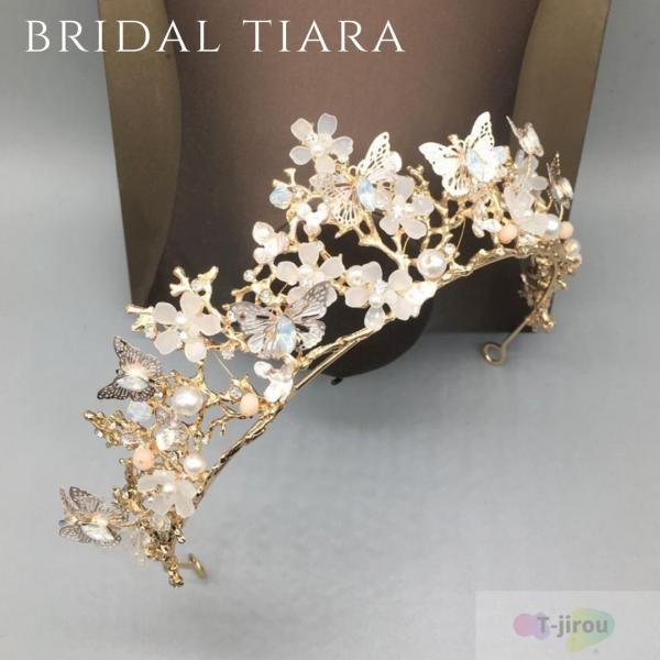 少し赤のあるピンクゴールドに蝶と花の細工やビジューがちりばめられたティアラになります。サイズは約横15cm、高さ6.5ｃｍになります。コームのないプリンセスタイプになります。細工がきれいな一品になっております。ブライダルと言わずパーティー等...