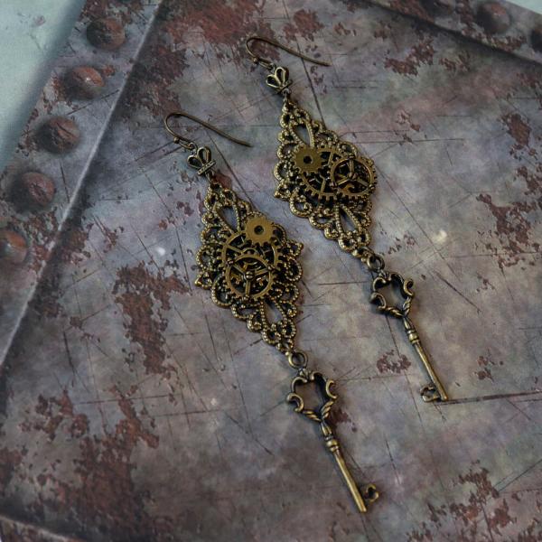 【ティアーズヘブンオリジナル】歯車パーツを使用したスチームパンク系ピアスひし形のプレイトに歯車　鍵が揺れるフックタイプピアスパーツの下には小さなクラウンパーツを使用他には無いオリジナルアクセサリーです。*一つ一つハンドメイドの為、歯車の位置...