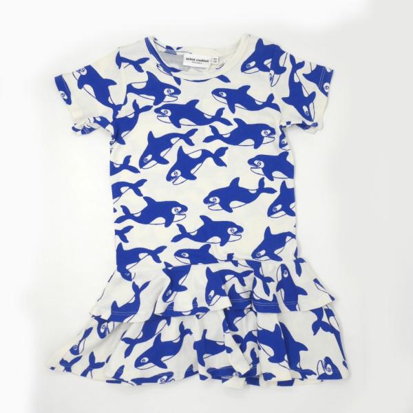 白地に鮮やかなブルーのシャチが爽やかなTシャツ素材のワンピース。海の生き物が好きなお子さんにお勧めのデザインです。裾部分のゆったりとしたフリルが女の子らしいポイントに。するどい歯を持ったシャチの表情がとてもかっこいいです。サイズ：104-1...