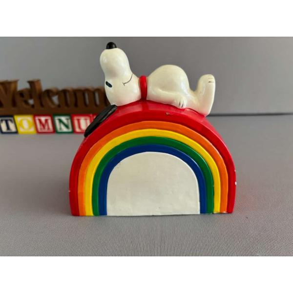 1970年代にアメリカDetermined社から発売されたスヌーピーのコインバンクです。陶器のような質感ですがパピエマシェという裁断した紙を水で溶きプレスで成形しペイントする手法で作られたものです。いつものように自分の犬小屋の上ではなく虹の...