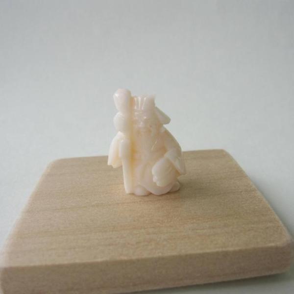 健康長寿・延命長寿・家庭円満や福徳円満などご利益がある神様です。1点もののお値打ち品です。玄関やリビングなどに飾ってみませんか？丁寧な彫りで、艶良く仕上がっています。白珊瑚大きさ（約）：W20×H26.5ミリ厚み：約13ミリ重さ：7.1ｇ飾り台付