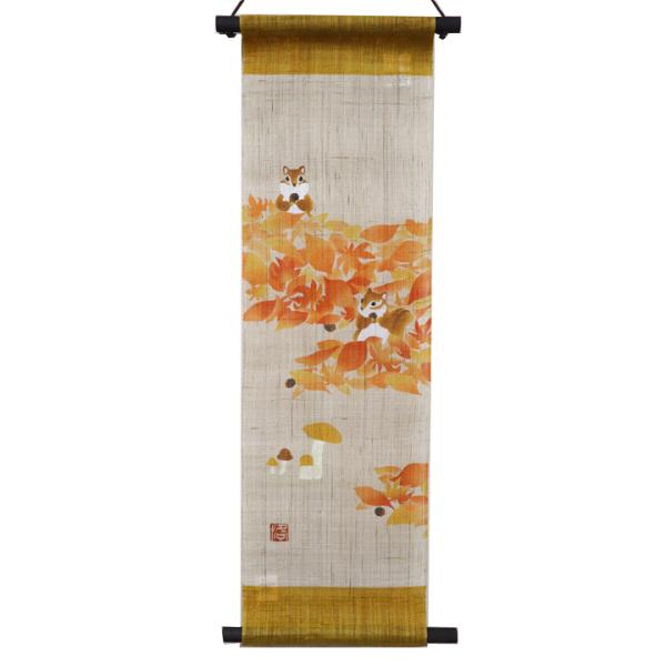 ちょっとしたスペースにも掛けられ、さりげなく季節感を演出してくれる小ぶりサイズの和みタペストリー。秋の恵みを満喫するリスたちを、色褪せぬ美しい落ち葉と共に手描きいたしました。このタペストリーは幅１８センチ、長さ６０センチの小さめサイズなので...