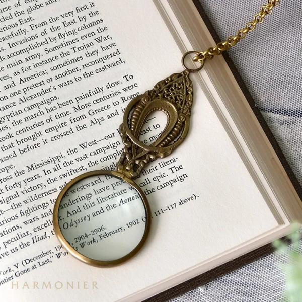 アンティーク調のおしゃれなブラス（真鍮）製のルーペのペンダントです。リボンとクラシカルなレリーフをあしらったシックなデザインです。本物のアンティークの様に趣のある風合いで、クラシカルなファッションにぴったりなアクセサリーです。インテリアのア...