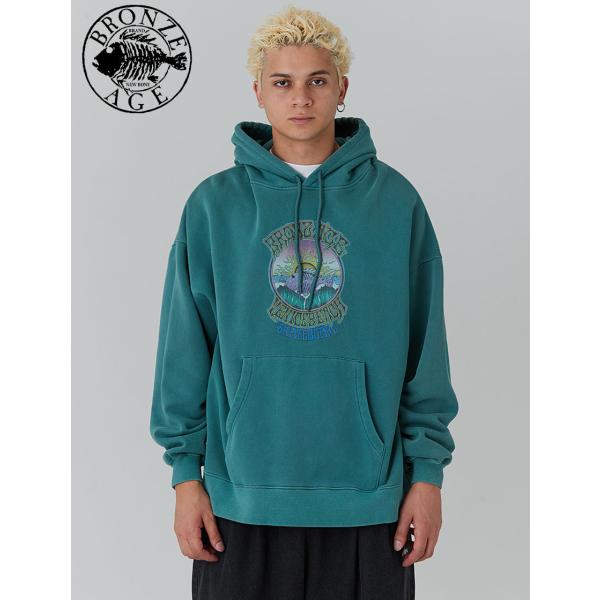 BRONZE AGEの製品染めプルオーバーパーカー。ビッグシルエットです。ブランドアイコンであるスカルフィッシュのグラフィックをフロントに配置。バックにはブランドロゴをプリントしました。ボディはピグメントバイオ加工を施し、古着アイテムらしさ...