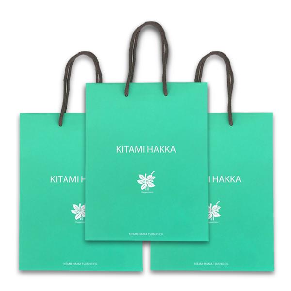 北見ハッカ通商オリジナルのギフト用手提げ紙バッグ。3袋セット。爽やかなペパーミントグリーンの表面と、清潔感のあるホワイトの裏面のコントラストが鮮やかで、中央に北見ハッカ通商のシンボルマークの「ハッカの葉」が配置されており、シンプルながら上品...