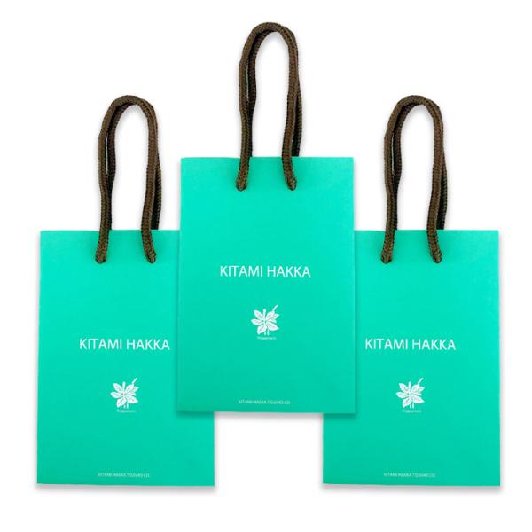 北見ハッカ通商オリジナルのギフト用手提げ紙バッグ。3袋セット。爽やかなペパーミントグリーンの表面と、清潔感のあるホワイトの裏面のコントラストが鮮やかで、中央に北見ハッカ通商のシンボルマークの「ハッカの葉」が配置されており、シンプルながら上品...