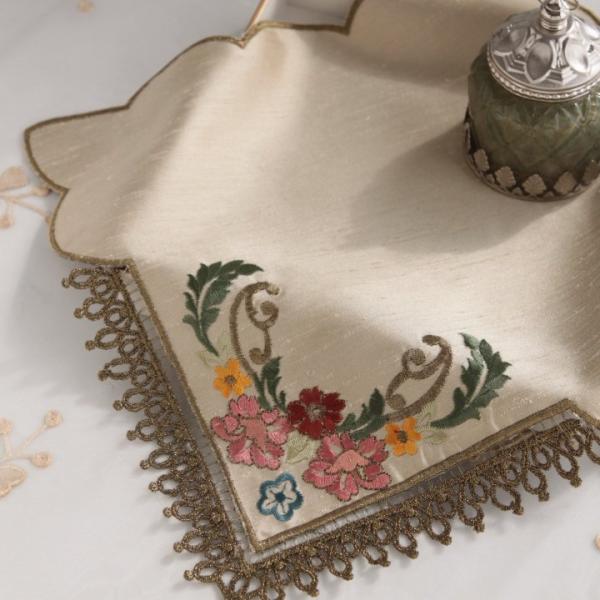 ギリシャ製の高級感のあるミニテーブルクロス。上品でクラシカルなモカベージュカラー。光沢のあるかわいいシルエットのクロスに繊細な花柄の刺繍、クロッシェ風のレース飾りなど、ディテールまでこだわったデザイン。テーブルセンターやティータイムのプレー...