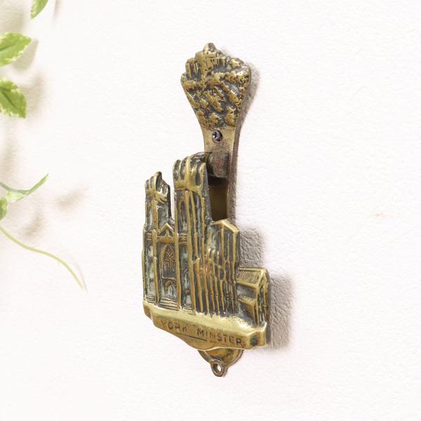 ドアノッカーの荘厳な建物のモチーフはイギリス、ヨークにあるヨーク大聖堂。イングランド国教会の大聖堂です。このドアノッカーは大聖堂の下にしっかりと「YORK MINSTER」と刻まれているので、もしかしたらスーベニアとして作られたものかも？な...