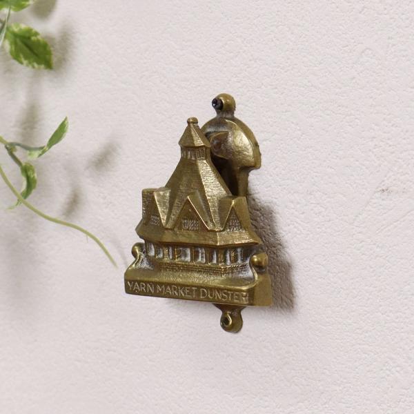 立体的な作りになったドアノッカーは、オシャレな屋根の建物がモチーフ。この建物はイギリスのサマセット州ダンスターにあるヤーン・マーケット。17 世紀初頭に建設され、、現在はグレード I の指定建造物および指定建造物に指定されている歴史的建物で...