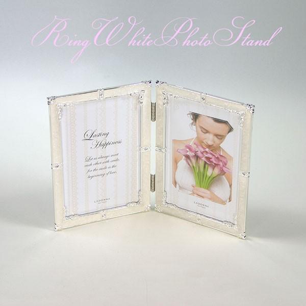 フレームにリングのようなクリスタルがはめこんだモチーフがあしらってある、とてもキレイな写真立てです。カップルの写真を左右にいれて飾ってもステキです。壁掛けにも利用できます。金属製。サイズ：22.5×16×畳んだ状態の厚さ/3cm、写真サイズ...