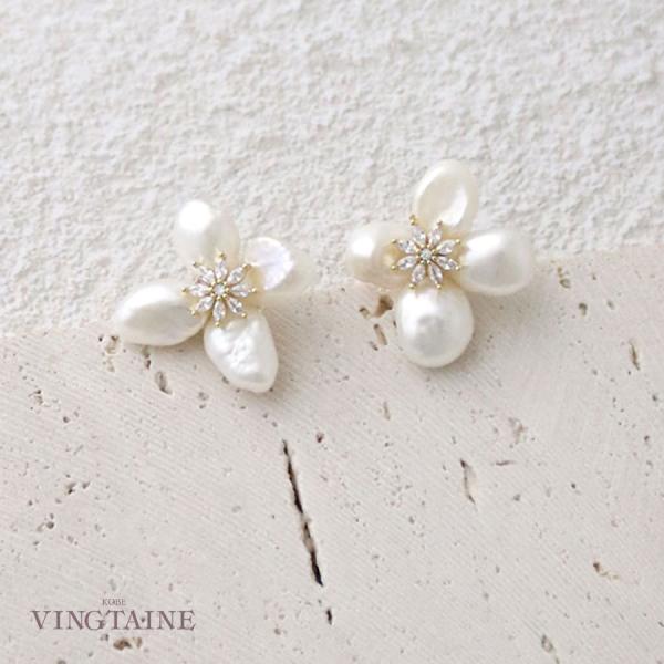 淡水パールの花びらが華やかなピアス、イヤリング艶やかな淡水パールを贅沢にあしらった、フラワーモチーフのピアス、イヤリング。中央には繊細に輝くクリスタルが散りばめられ、上品さと華やかさを兼ね備えたデザインです。耳元で優しく咲き誇る花が、顔周り...
