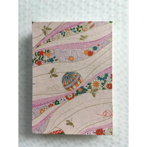 A6判10,8×15,1cm(表紙)　1,4cm厚　100g。　表紙:友禅和紙　毬　うす桃 / 表裏が同じ絵柄。(絵柄は写真と同じ位置には入っていません)本文中紙:奉書紙 にじむ　蛇腹タイプ10山　22ページ　*表書き用ラベルを同封。お好み...