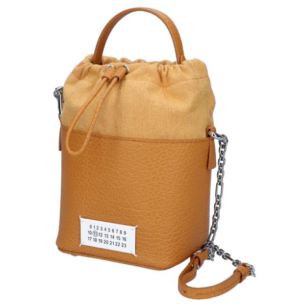 メゾンマルジェラ MAISON MARGIELA上質レザーとキャンバス地の異素材を使用し、ドローストリング開閉とバケット型のシルエットがキュートなバケットバッグ。持ちやすいワンハンドルとフロントのカレンダータグがポイント。底鋲の形違いのデザ...