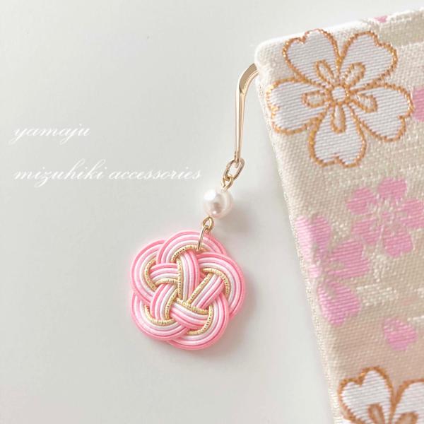 日本の伝統工芸「水引」で一つひとつ丁寧に結んでいます。愛らしい梅の花は、「良縁」や「幸福」の意味を持つ縁起の良い結びです。金具は使いやすいサイズで、引っかけても落ちにくく、安心してご使用いいただけます。屋外での御朱印帳の使用時や順番待ちの際...