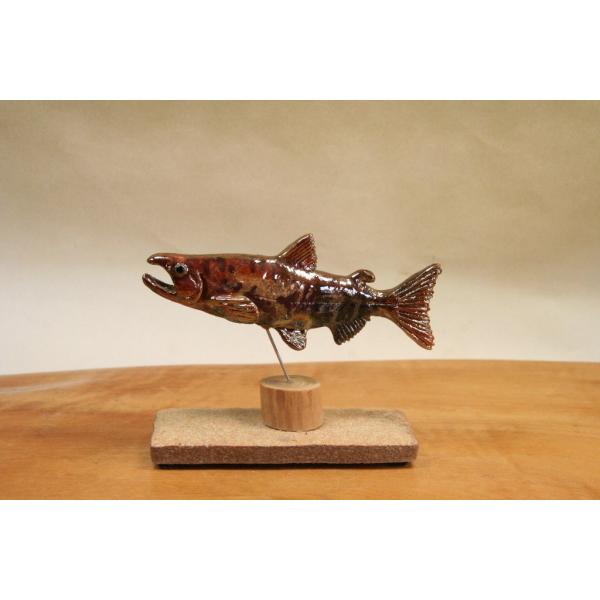 サケの置物です。多くの着色技法を一匹の中に集中させ、本物のような質感を出します。模様は一つ一つ筆で置いていきます。複雑な絵付けとなっております。全体とラスター彩はエアブラシを使用しています。本体・全長約10.5cm高さ4cm幅2.7cm。台...