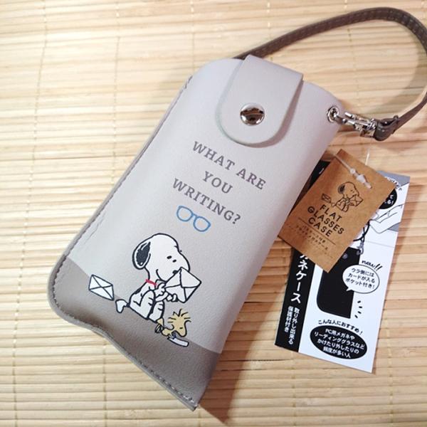 バッグにつけて持ち歩ける SNOOPYのフラットメガネケースです。可愛い！ミニバッグの様に見える、保護材入りメガネケース。裏面にはカードや定期が入るポケット付き！サングラスやリーディンググラスなど、サッと使いたいときに取り出せます。中の保護...