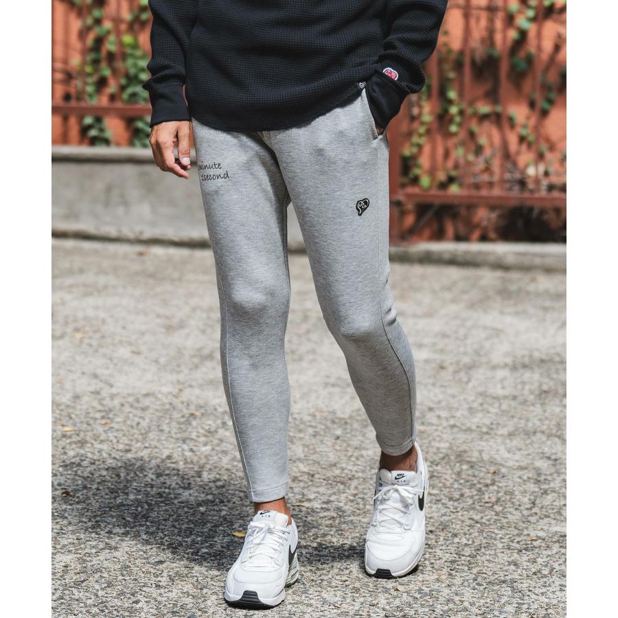 1minute 1second（ワンミニットワンセカンド） パンツ cursive print cardboard knit pants ...